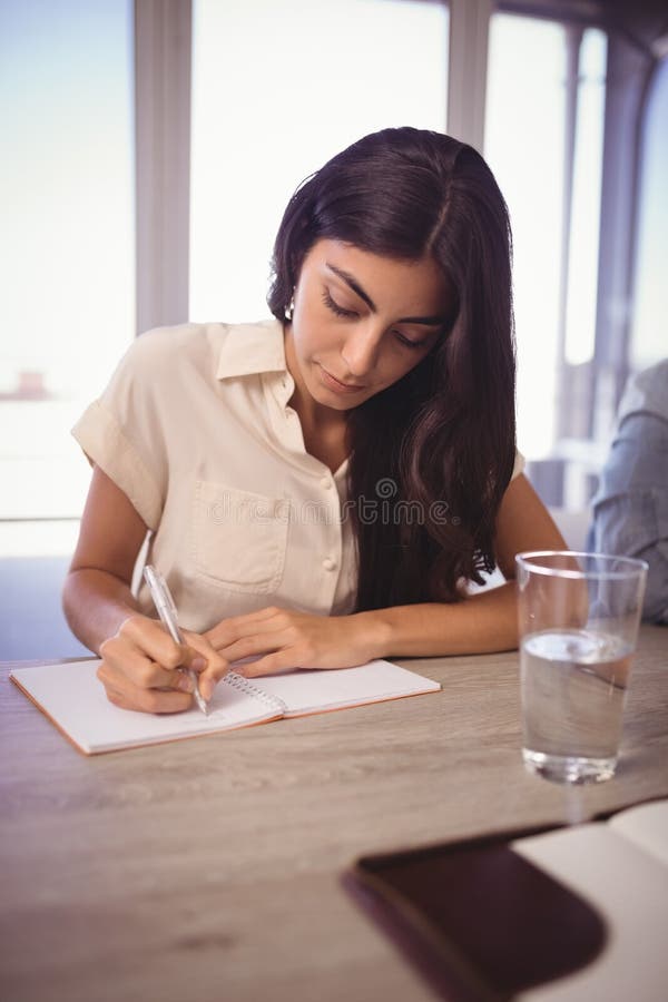 Businesswoman Making Notes during Meeting in Office Stock Photo - Image ...