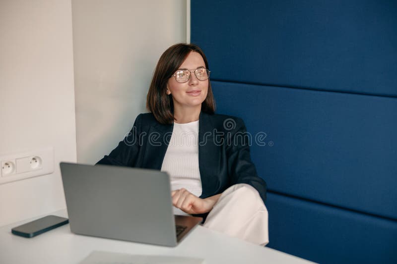 A Businesswoman in a Modern Office is Focused on Laptop Work ...