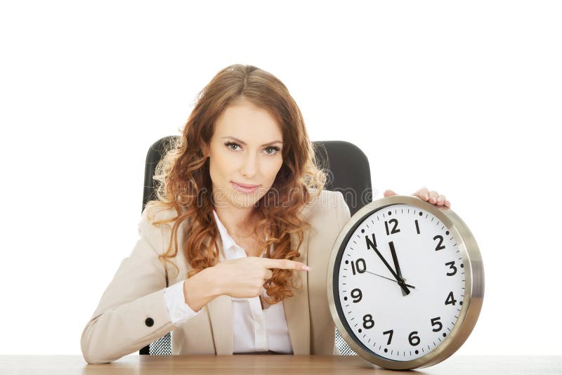 Businesswoman Pointing on a Clock by a Desk. Stock Image - Image of ...