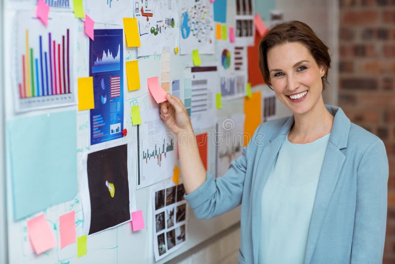 Businesswoman Putting Sticky Notes on Whiteboard Stock Photo - Image of ...
