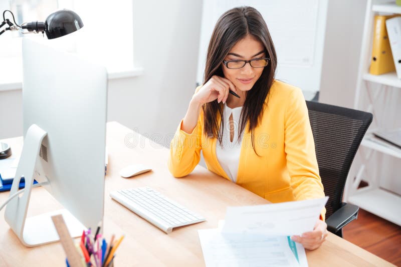Businesswoman Reading Paper at Her Workplace Stock Image - Image of ...