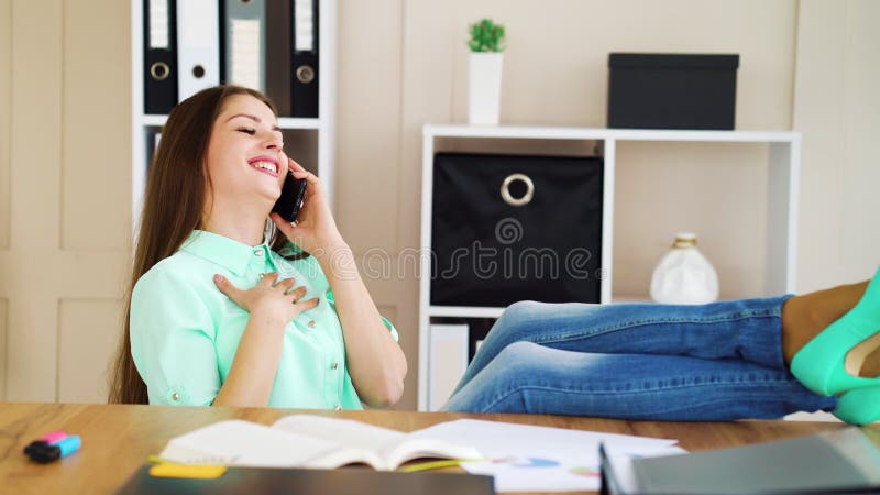 Businesswoman Relaxing At Work With Feet On Table And Talking On Phone