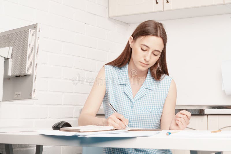 Businesswoman is Sitting at His Desk and Writing in a Notebook. Stock ...