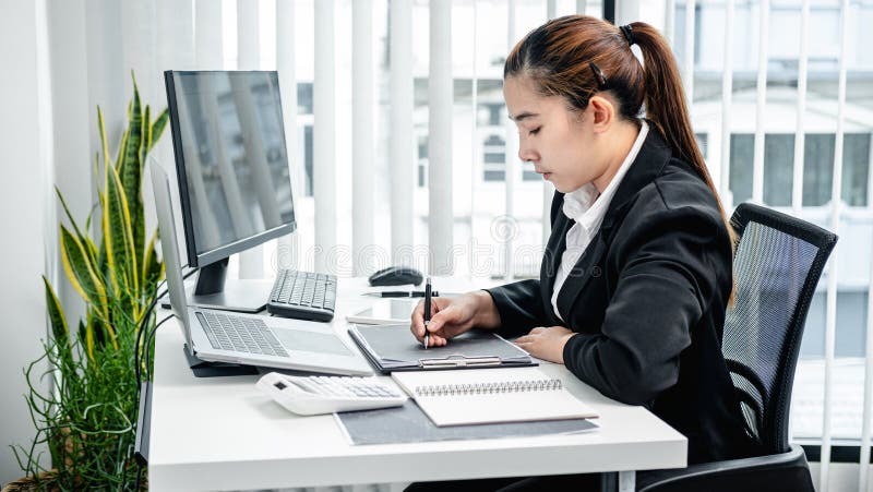 Businesswoman is Taking Note in Stock Data Chart on Document and ...