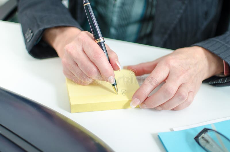Businesswoman Taking Notes on a Post it Stock Photo - Image of ...