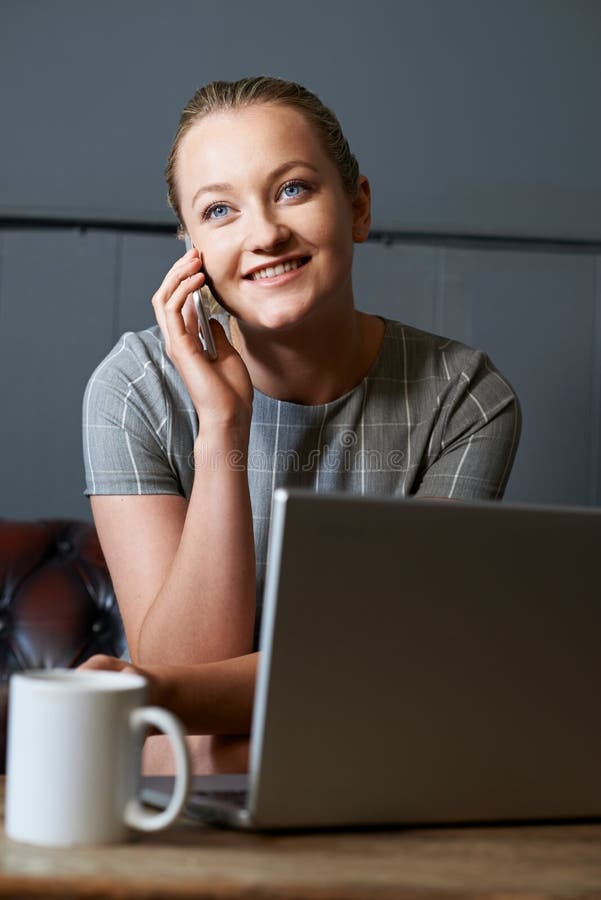 Businesswoman Talking on Mobile Phone Working on Laptop in Inter Stock ...