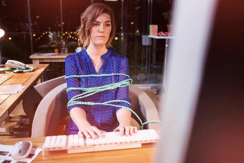 Businesswoman Tied with Rope while Working at Desk Stock Photo - Image ...