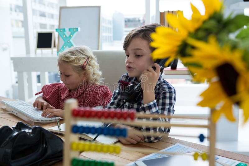 Businesswoman Using Computer while Coworker Talking on Phone in Office ...