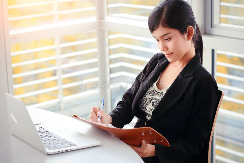 Businesswoman Using Computer while Taking Note on Notebook Stock Photo ...