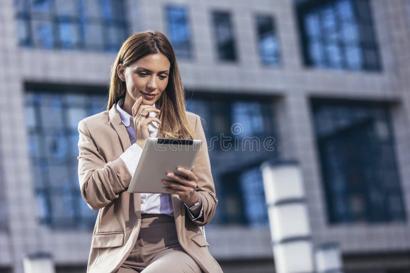 Businesswoman Using a Digital Tablet while Standing in Front of ...