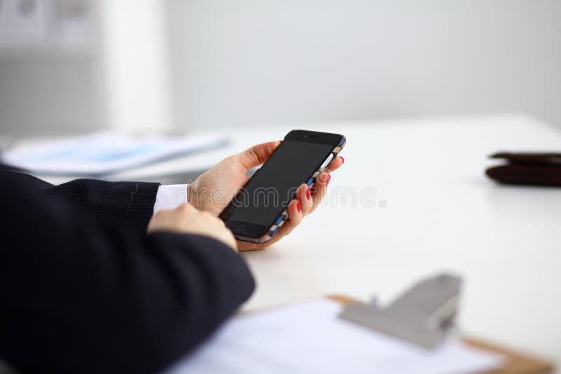 Businesswoman Using Her Phone in Office Sitting on the Desk Stock Image ...