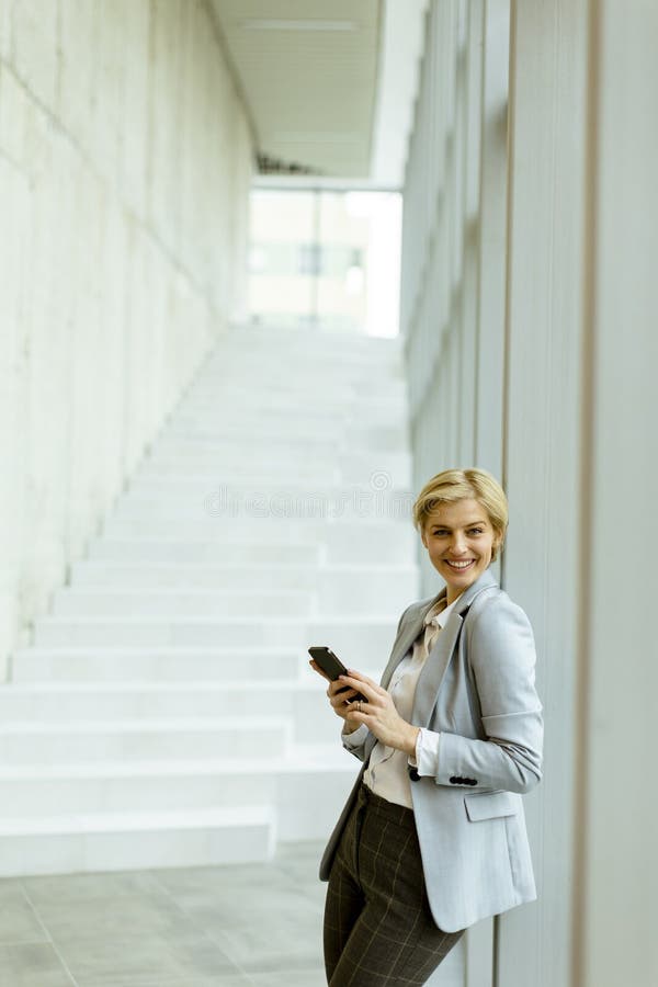 Businesswoman Using Mobile Phone on Modern Office Hallway Stock Image ... Businesswoman Using Mobile Phone on Modern Office Hallway Stock Image ...