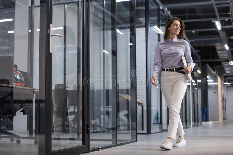 Businesswoman Walking Along the Office Corridor with Documents Stock ...