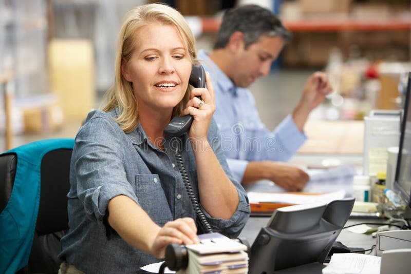Businesswoman Working at Desk in Warehouse Stock Image - Image of male ...