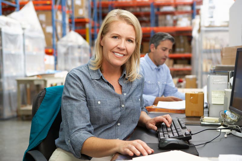 Businesswoman Working at Desk in Warehouse Stock Image - Image of male ...