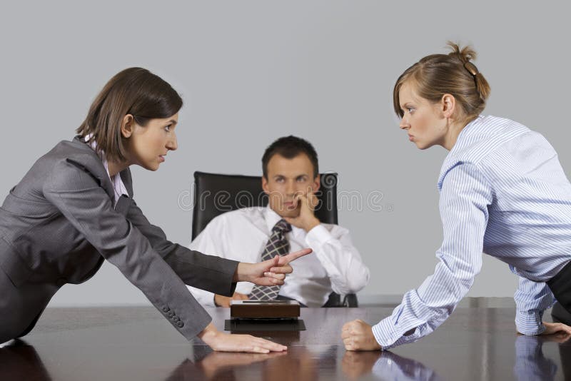 Businesswomen Arguing in Front of Businessman at Office Stock Photo ...