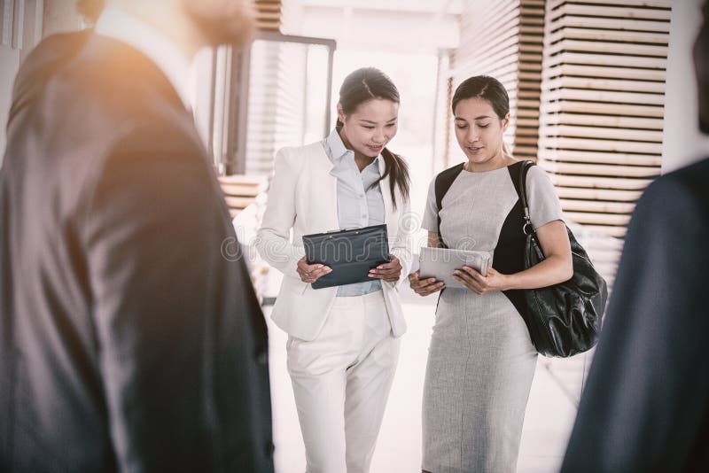 Businesswomen Having Conversation in Office Stock Image - Image of ...