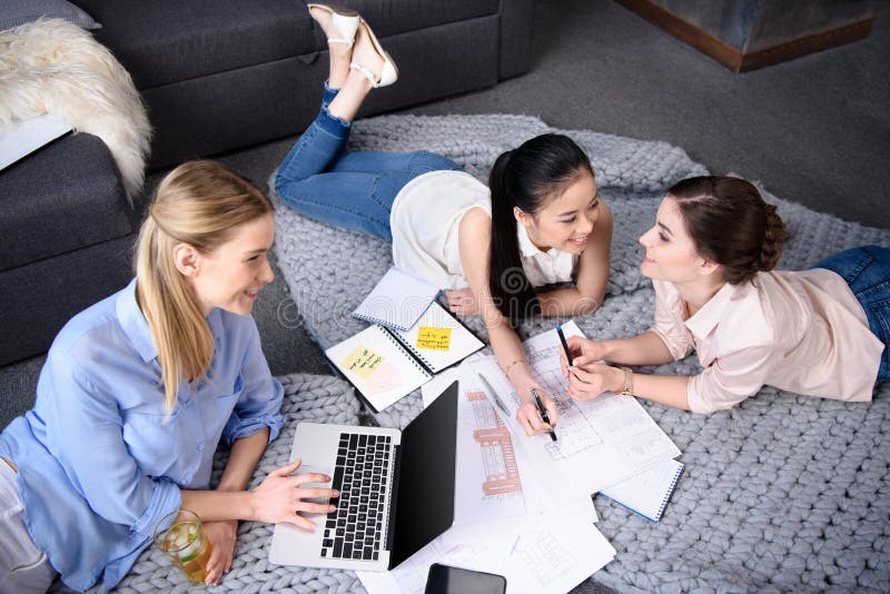 Businesswomen Having Discussion while Colleague Using Laptop Stock ...