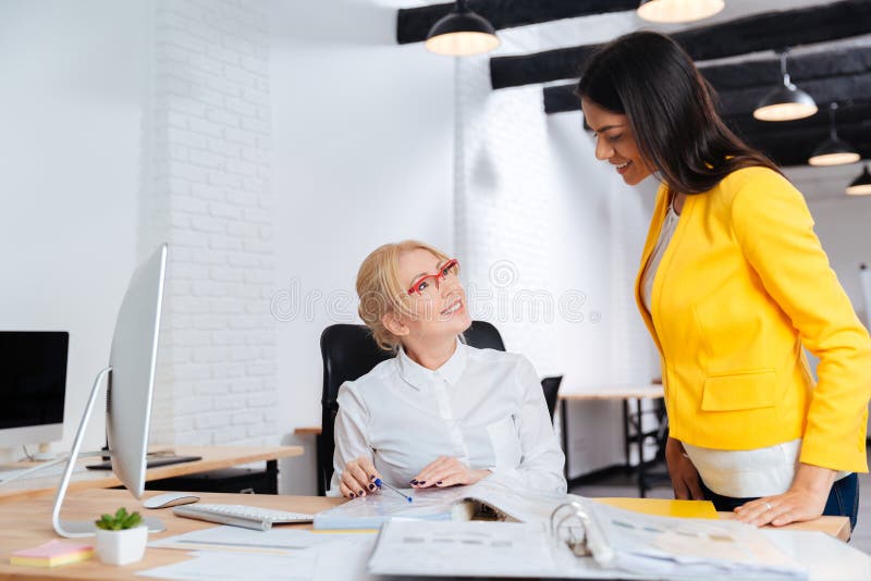 Businesswomen Talking and Smiling while Reviewing a Work Plan Stock ...