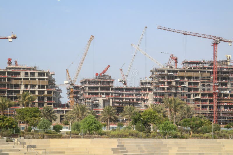 Bustling Construction Site with Cranes and Scaffolding Around a Multi ...