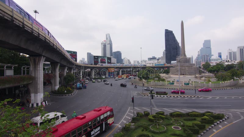 Bustling Intersection with Vehicles and Elevated Train Tracks in ...
