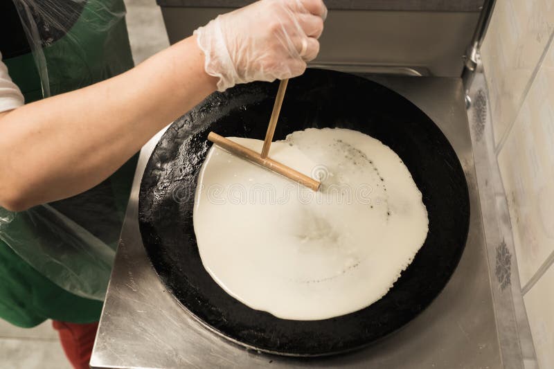 Chef Prepares Thin Crepe in a Kitchen Using a Flat Skillet at a Busy ...