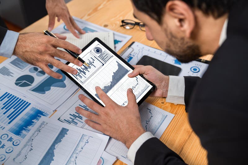 Busy Analyst Team Discussing Financial Data on Tablet. Fervent Stock ...