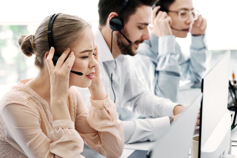 Busy Call Centre Assistants with Headsets Working in Front of Computer ...