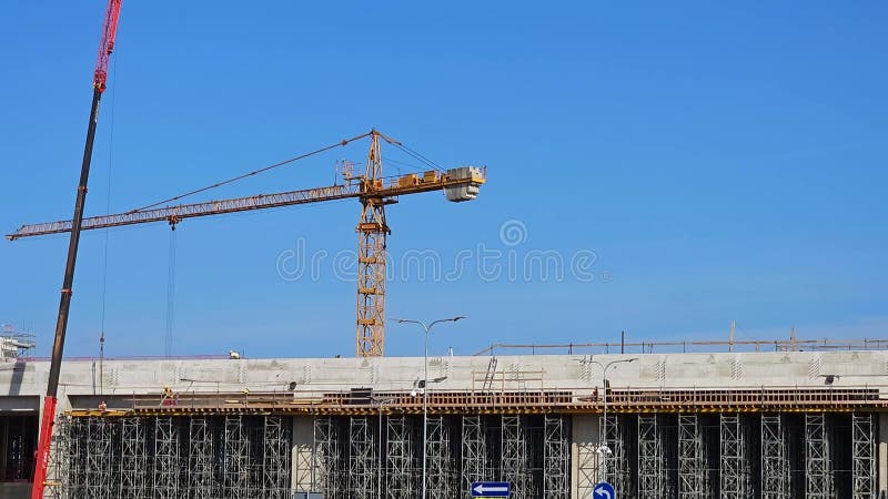 A Busy Construction Building with Workers Walking Across Concrete ...