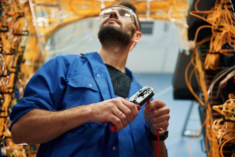 Busy by Cutting the Wire. Young Man is Working with Internet Equipment ...