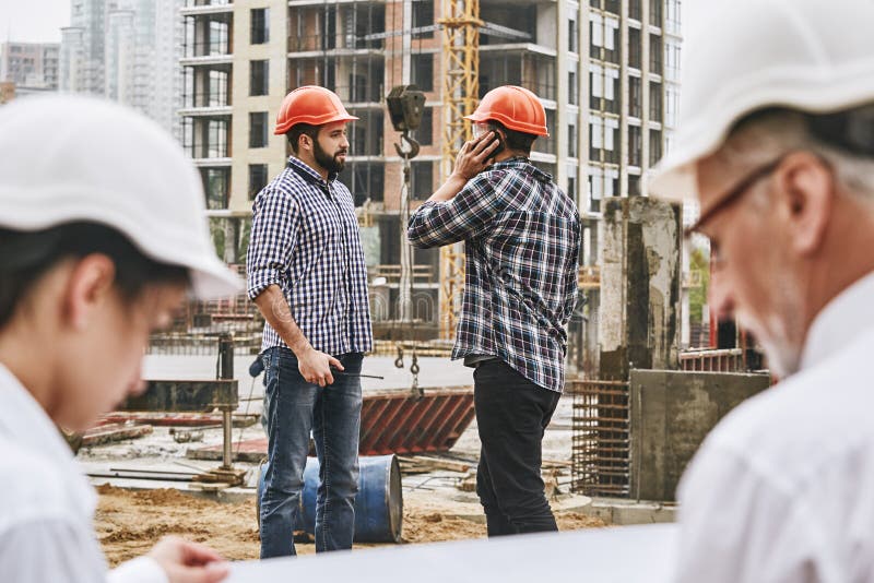 Busy Day. Team of Professional Engineers and Builders in Protective ...