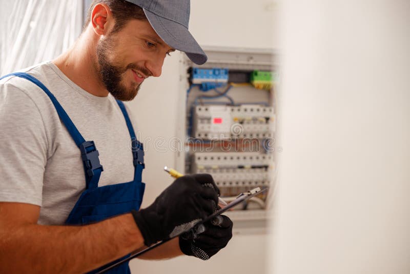 Busy Electrical Technician Writing on a Clipboard the Data Collected on ...