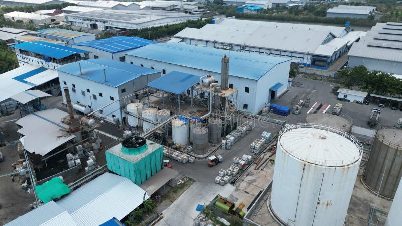 A Busy Factory with Large Tanks and Trucks Loading and Unloading. Stock ...