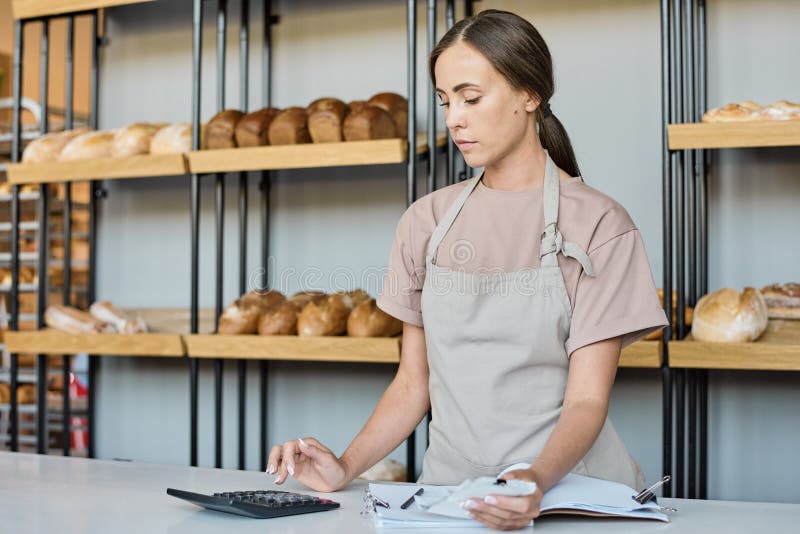 Busy Female Worker of Bakery Looking through Receits Stock Photo ...