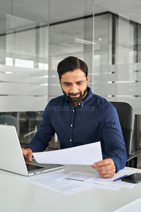 Busy Indian Business Man Reading Financial Document Using Computer ...