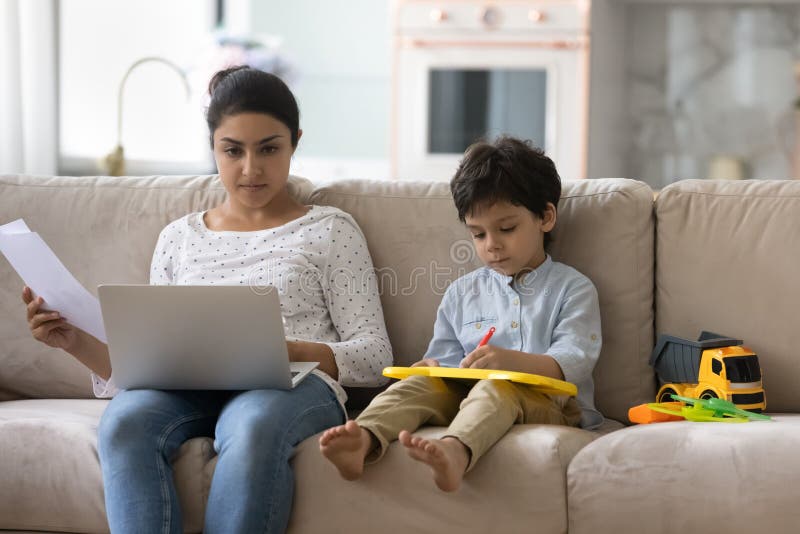 Busy Indian Mother Working at Home while Son Playing Stock Photo ...