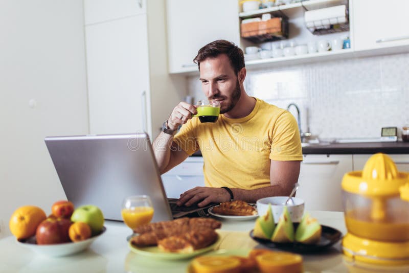 Man Working at Home, Using Laptop while Having Breakfast Stock Photo ...