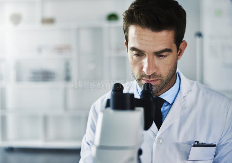 Busy with a New Breakthrough. Shot of a Scientist Using a Microscope in ...