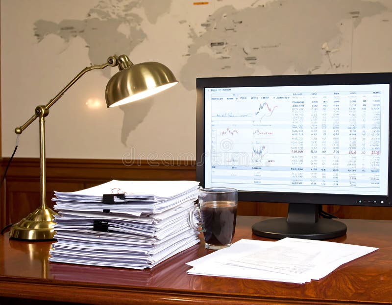 Busy Office Desktop with Financial Charts on a Computer Screen, Stacks ...
