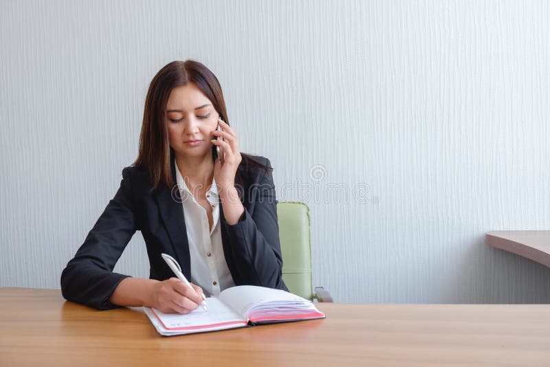 Busy Secretary is Answering Call and Writing Memo at the Same Time ...