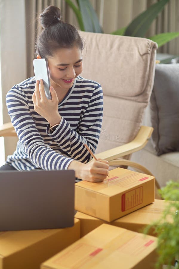 A Busy Small Business Owner is on the Phone while Preparing Her Parcel ...