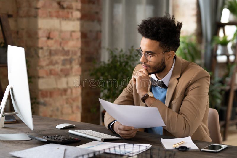 Busy African American Manager Comparing Data on Computer Stock Image ...