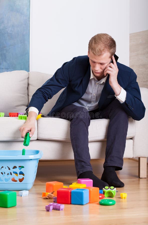 Busy young dad cleans toys stock image. Image of male - 43719779