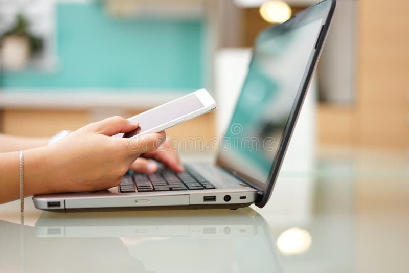 Busy Young Woman is Typing on Laptop Computer and Using Mobile P Stock ...