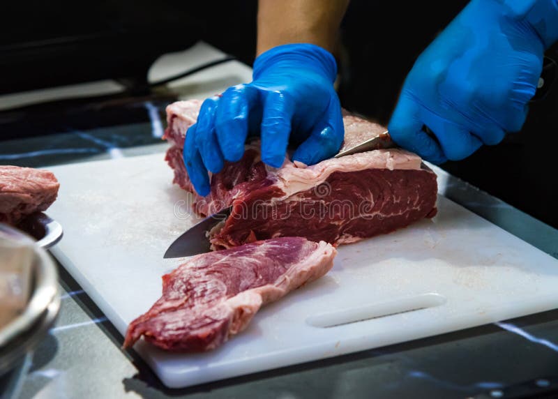 Butcher Cutting Raw Meat with Knife in the Kitchen Stock Photo - Image ...