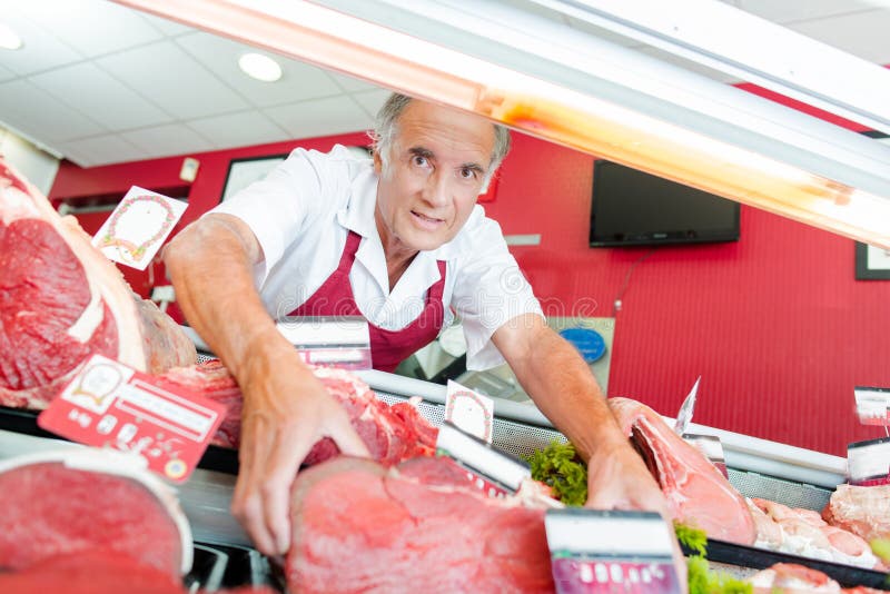 Butcher Placing Meat on Display Stock Image - Image of mature, deli ...