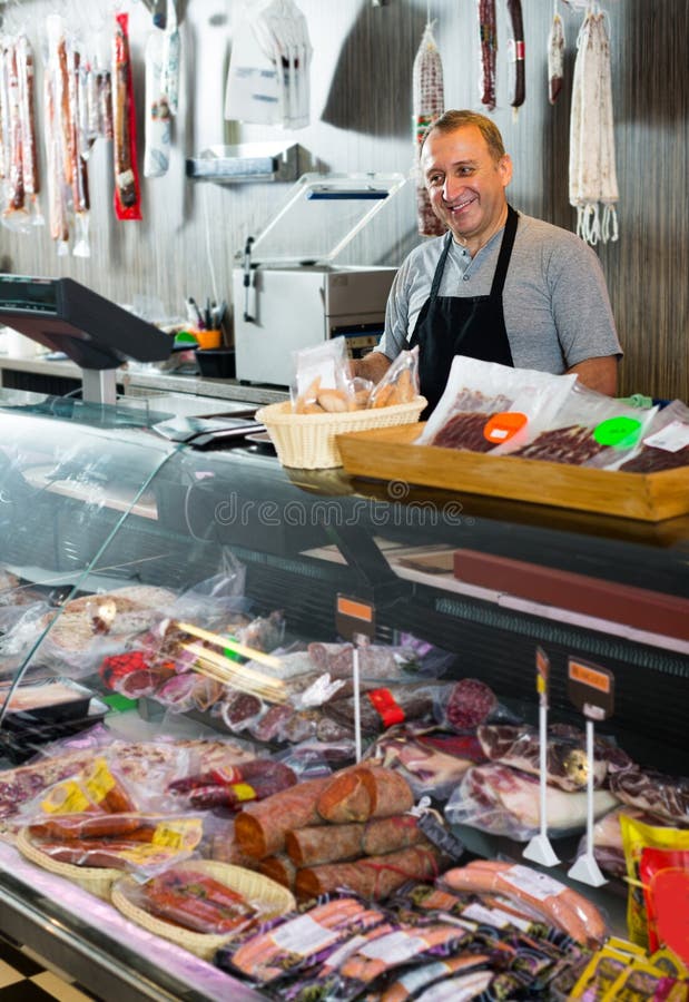 Butcher with smoked meat stock image. Image of assortment - 244722865