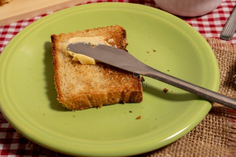 Spreading Butter on Toasted Bread for Breakfast on Green Plate Stock ...