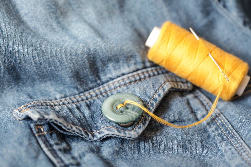 Buttons, Thread and Sewing Needle on Denim. Close-up Stock Image ...