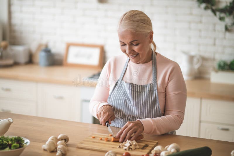 A Blonde Woman in Apron in the Kitchen Looking Busy Stock Photo - Image ...
